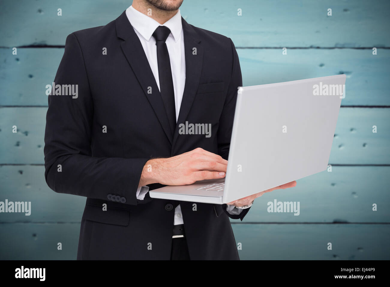 Composite image of mid section of a businessman using laptop Stock ...