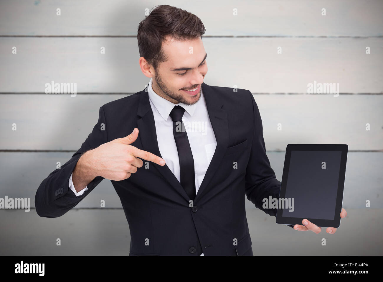 Composite image of happy businessman pointing with his tablet Stock ...