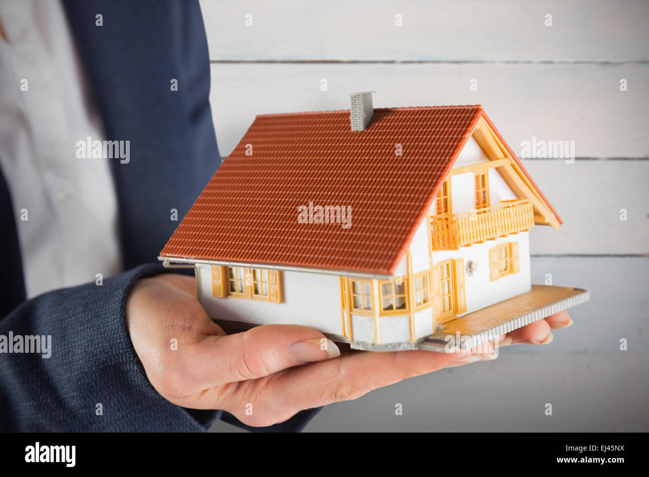 Composite image of estate agent showing mini house Stock Photo - Alamy