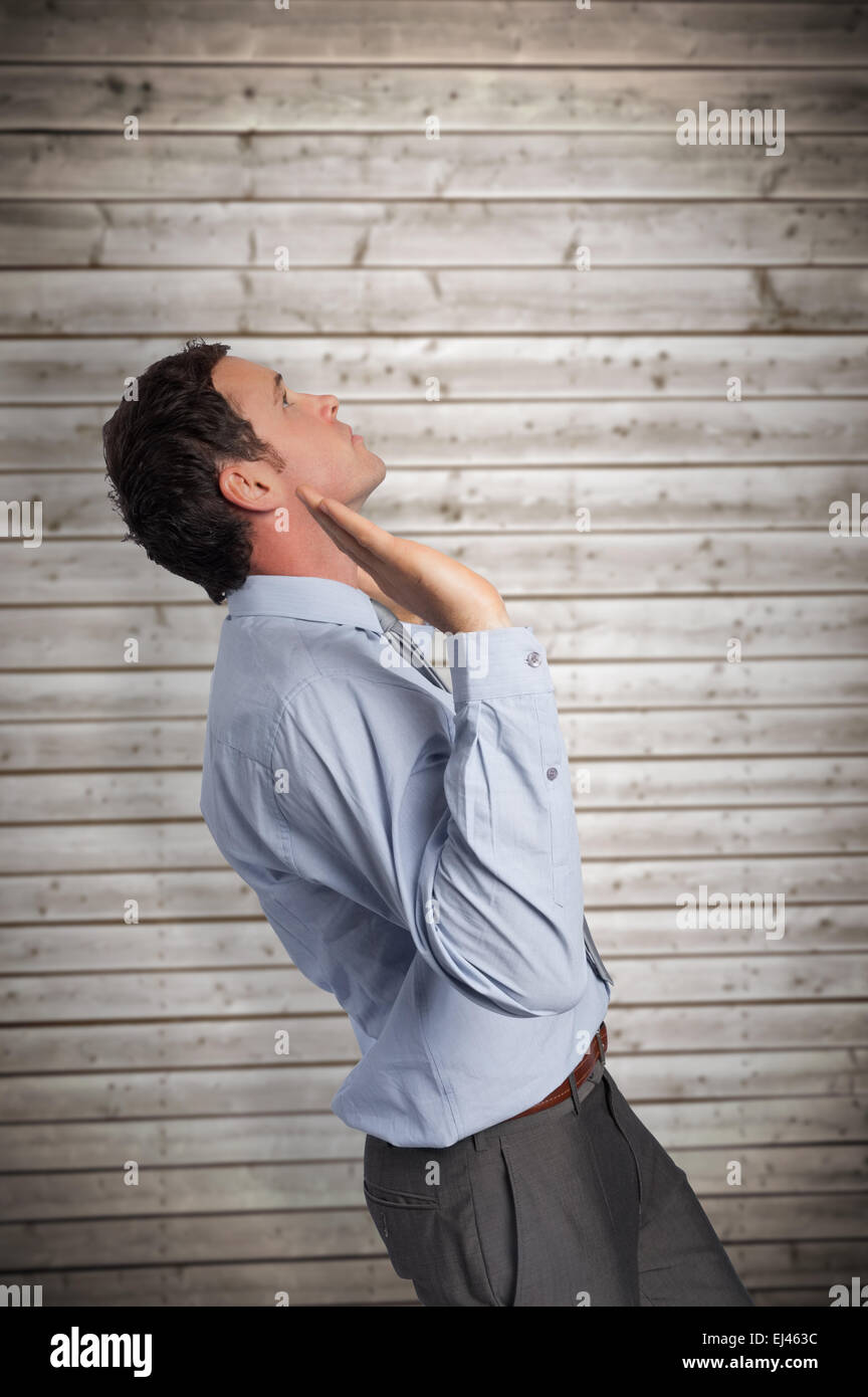 Businessman standing with arms pushing up against bright white room ...