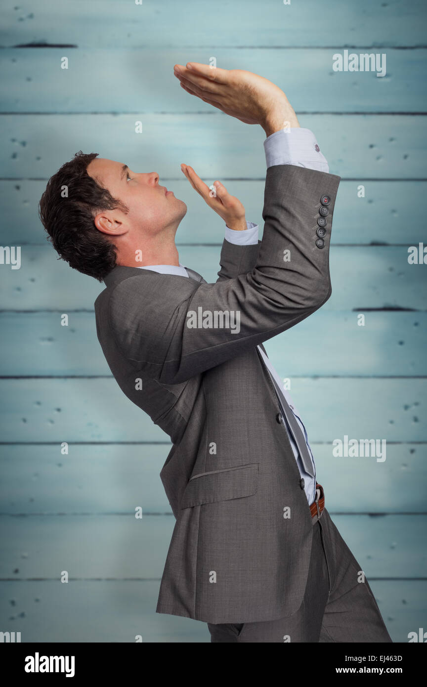 Composite image of businessman standing with arms pressing up Stock ...