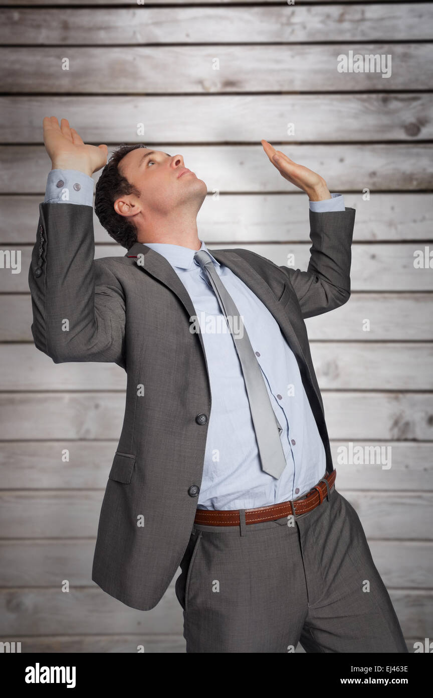 Composite image of businessman standing with arms pressing up Stock ...