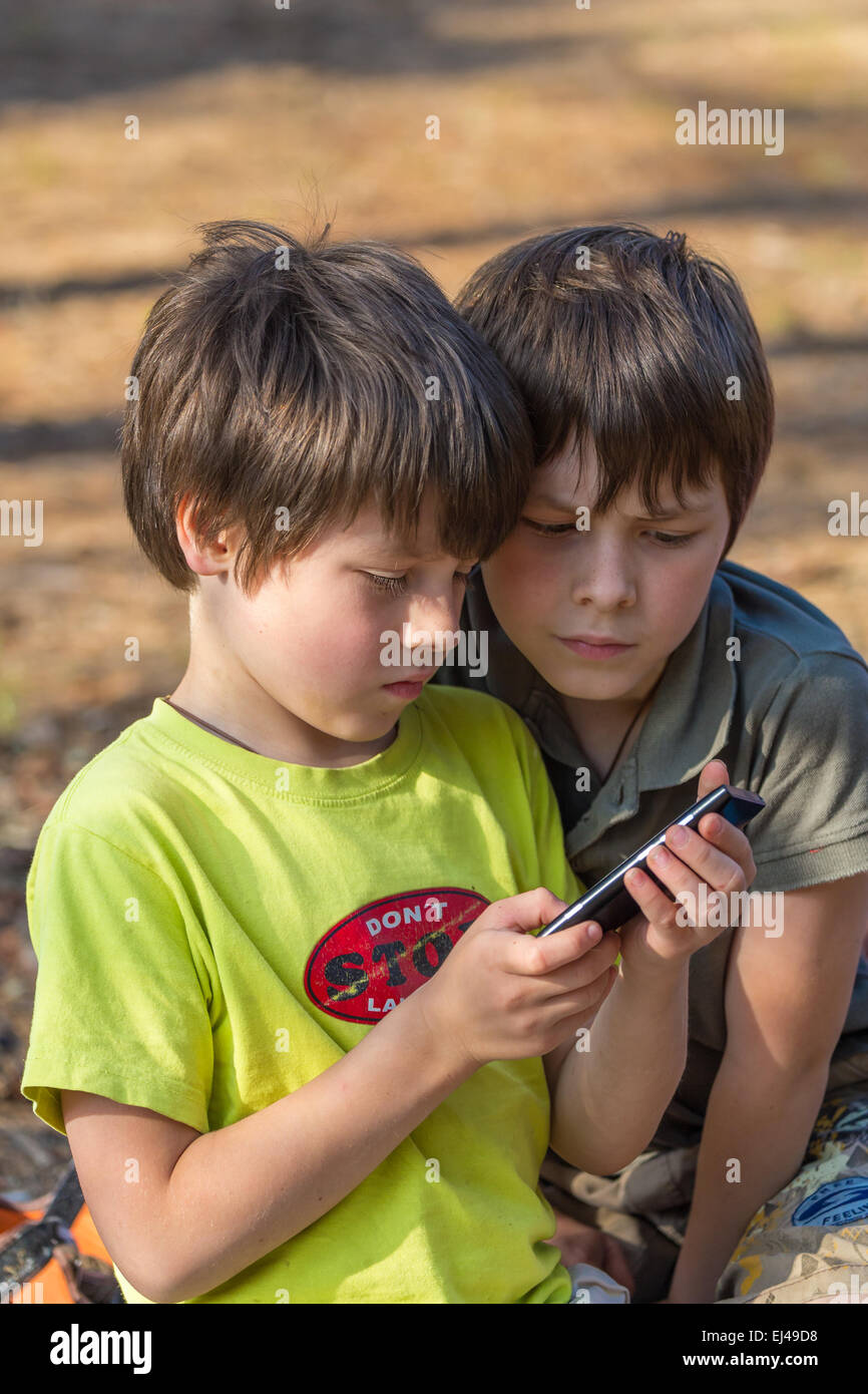 Children two little boys playing mobile phone outdoors Stock Photo - Alamy