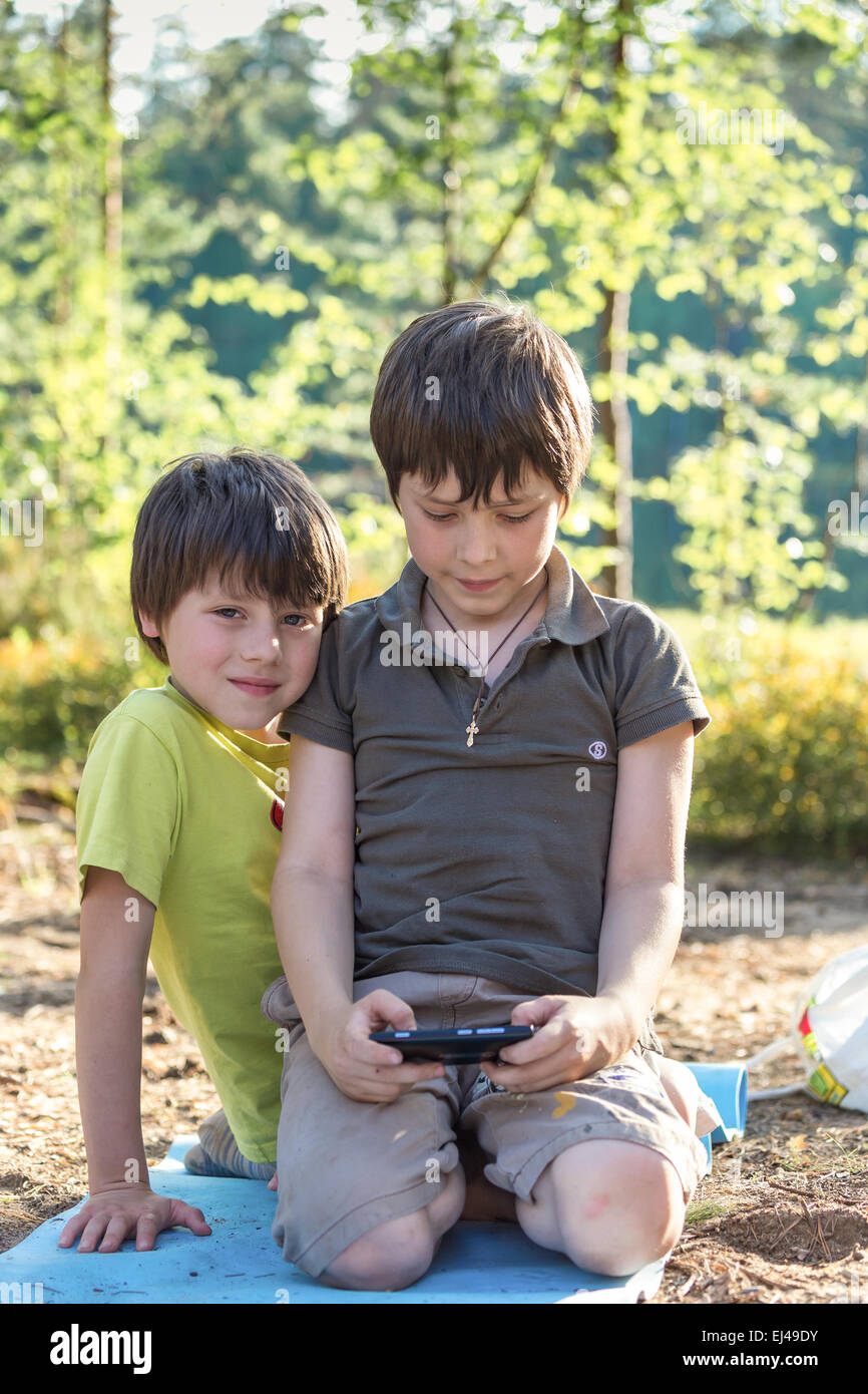 Children two little boys playing mobile phone outdoors Stock Photo - Alamy