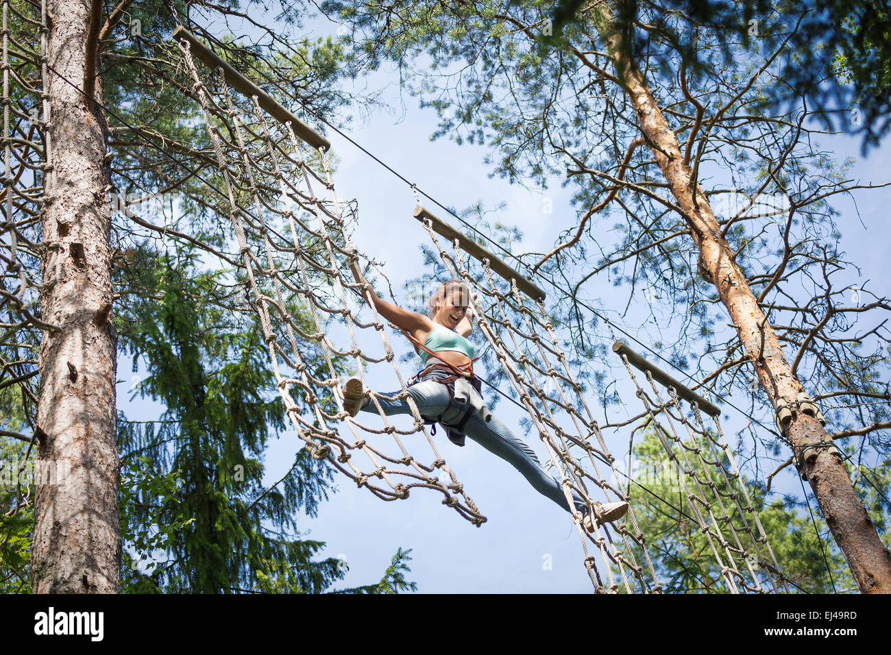 Woman at adventure rope park in forest Stock Photo - Alamy
