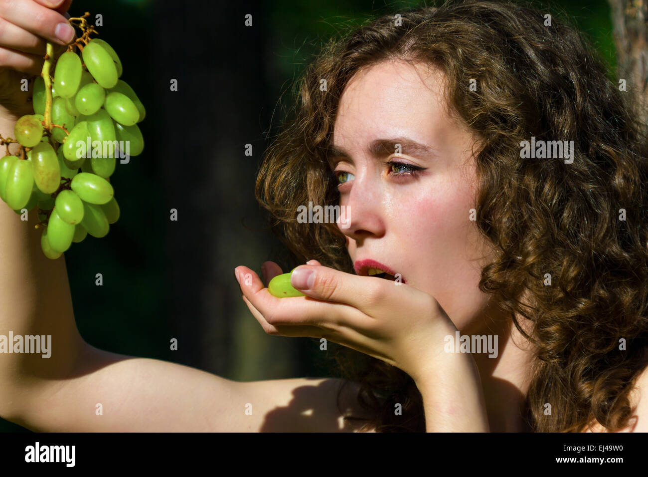 Pretty woman with grape snack outdoors snack Stock Photo - Alamy