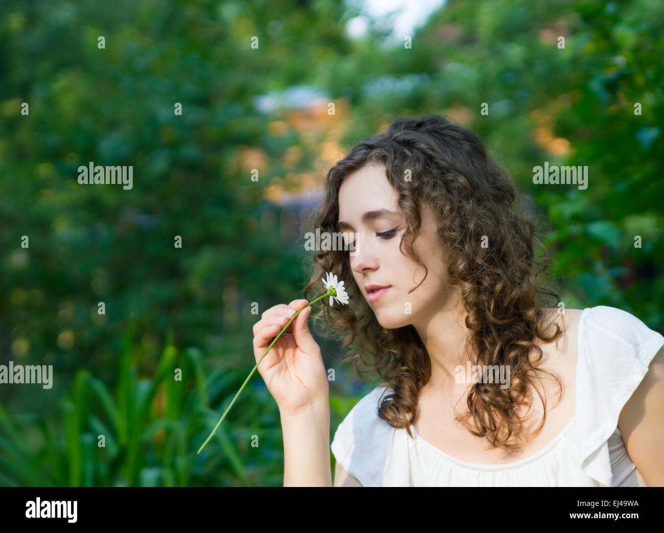 Beautiful romantic woman with daisy flower outdoors Stock Photo - Alamy