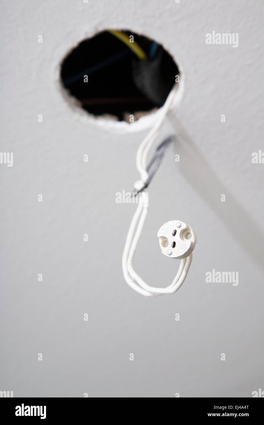 white indoor ceiling with circular hole cable with plug ready for ...