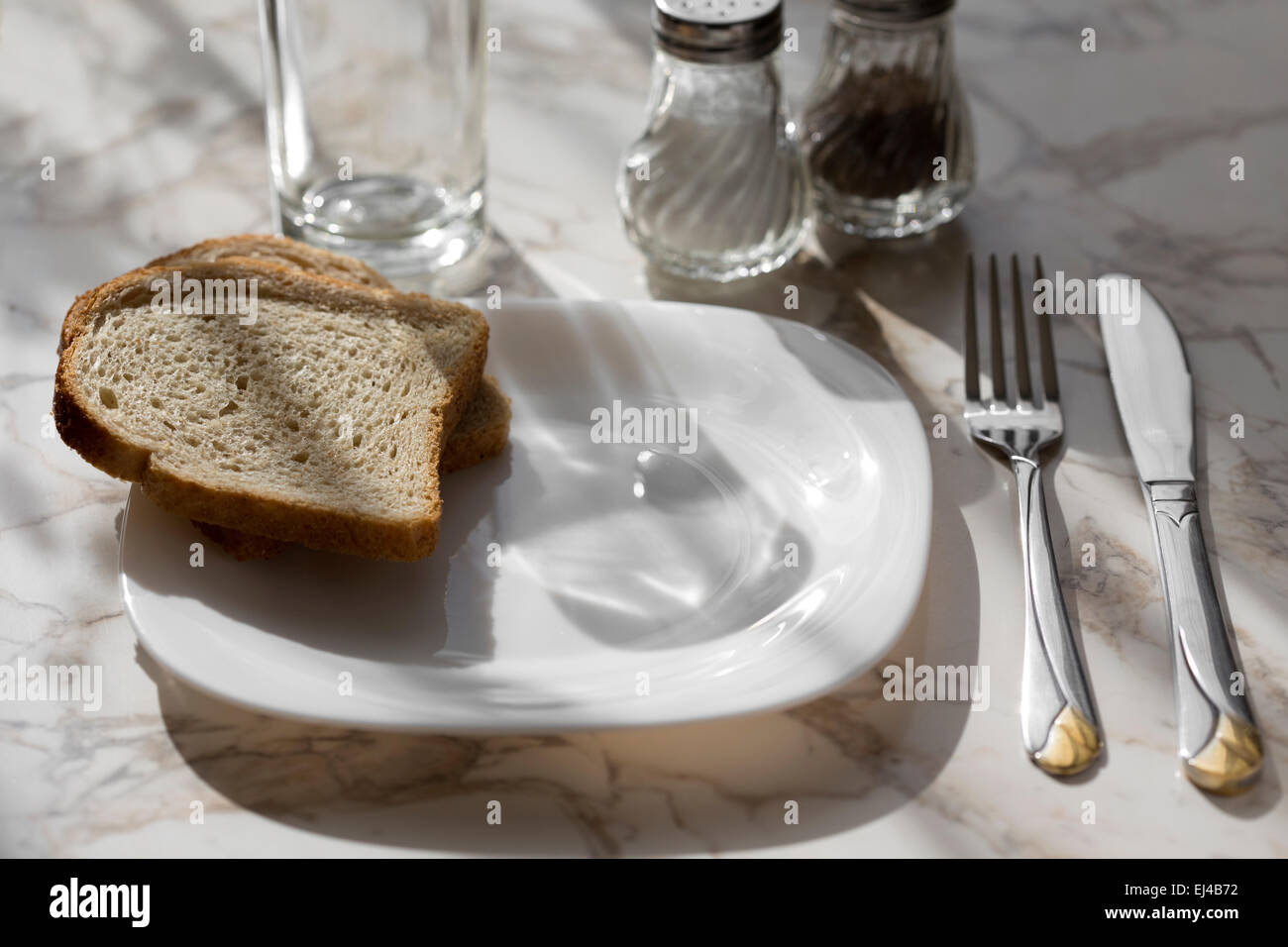Empty plate with bread on wooden table Stock Photo - Alamy