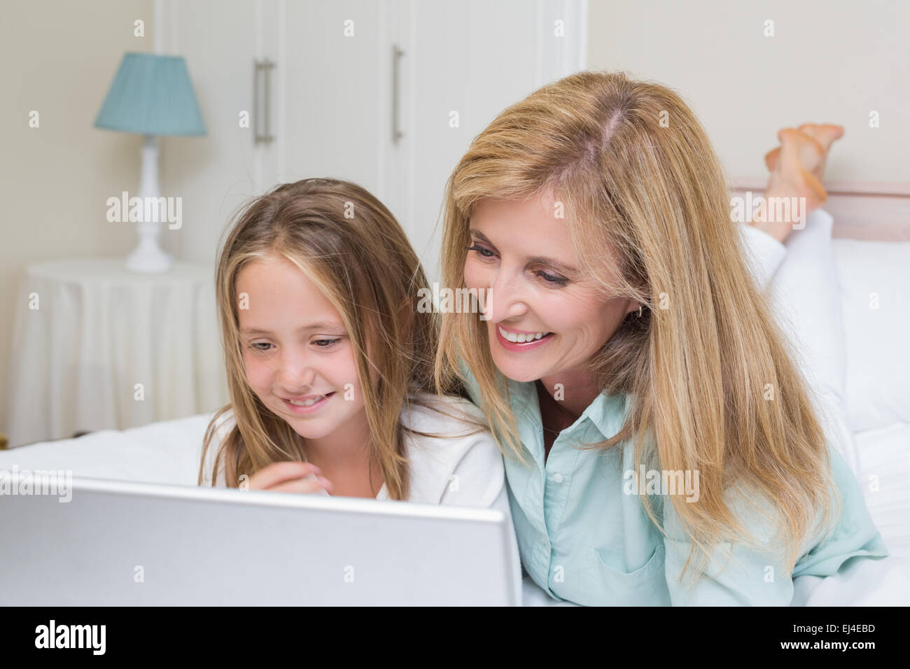 Happy mother and daughter using laptop Stock Photo - Alamy