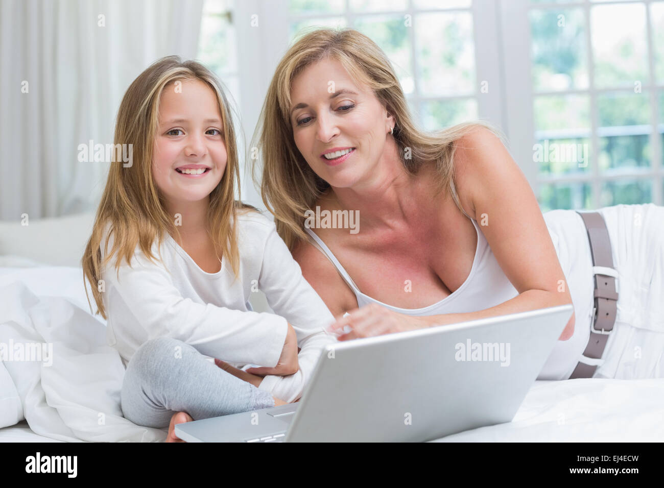 Mother and daughter using laptop in the bed Stock Photo - Alamy