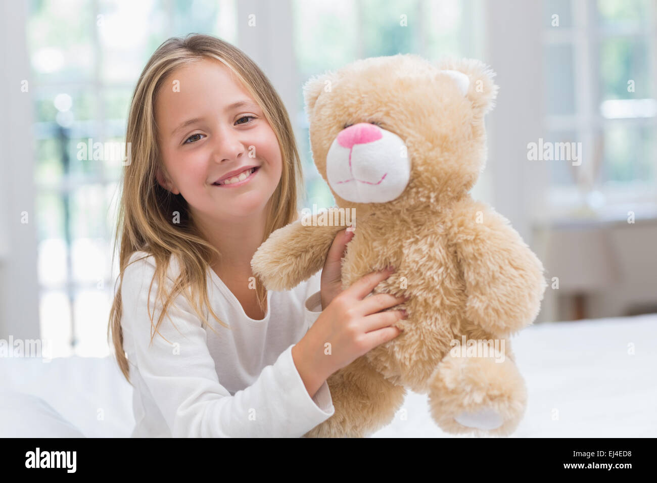 Happy little girl holding her teddy Stock Photo - Alamy