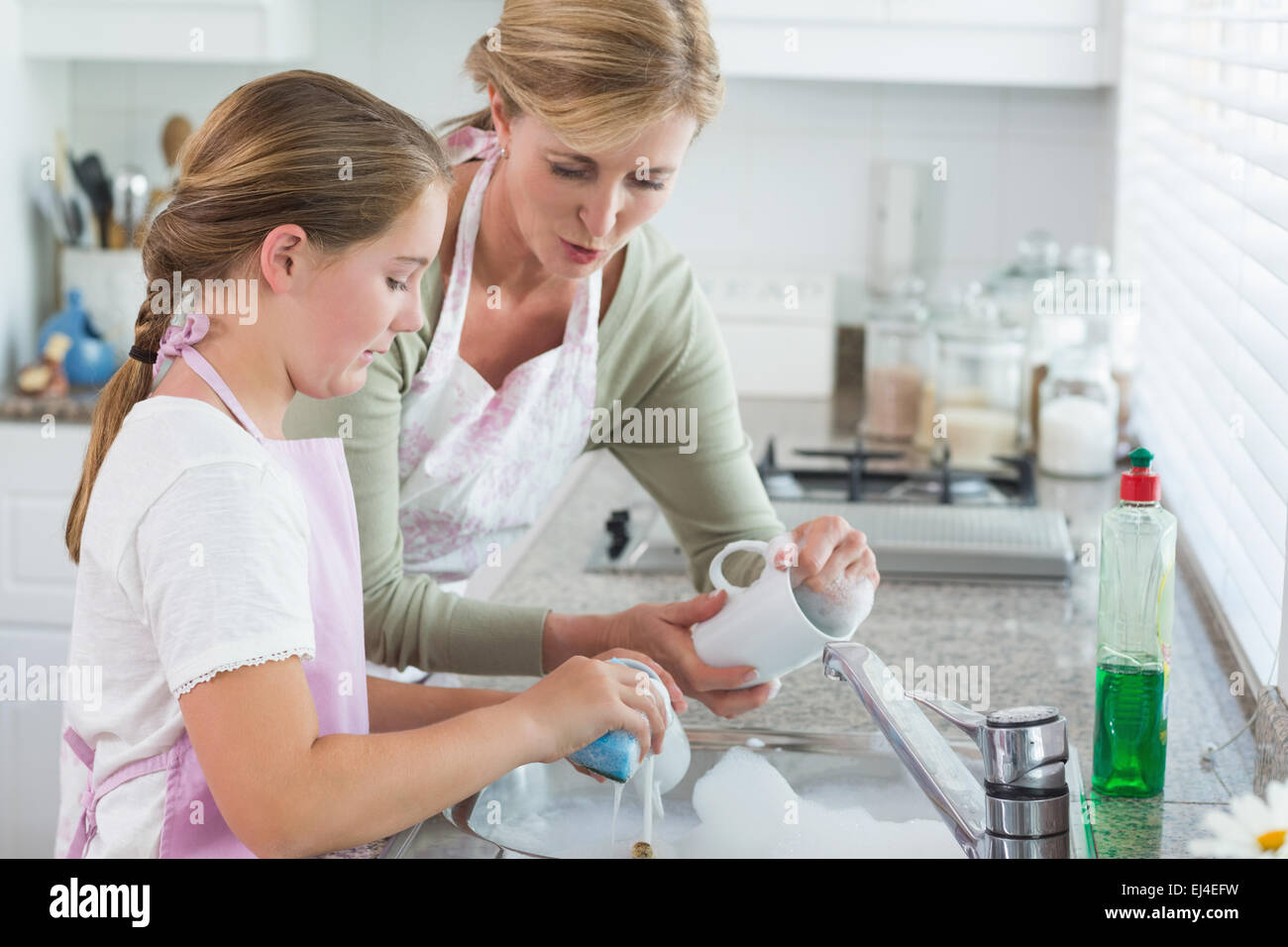 Mother and daughter washing up together Stock Photo - Alamy