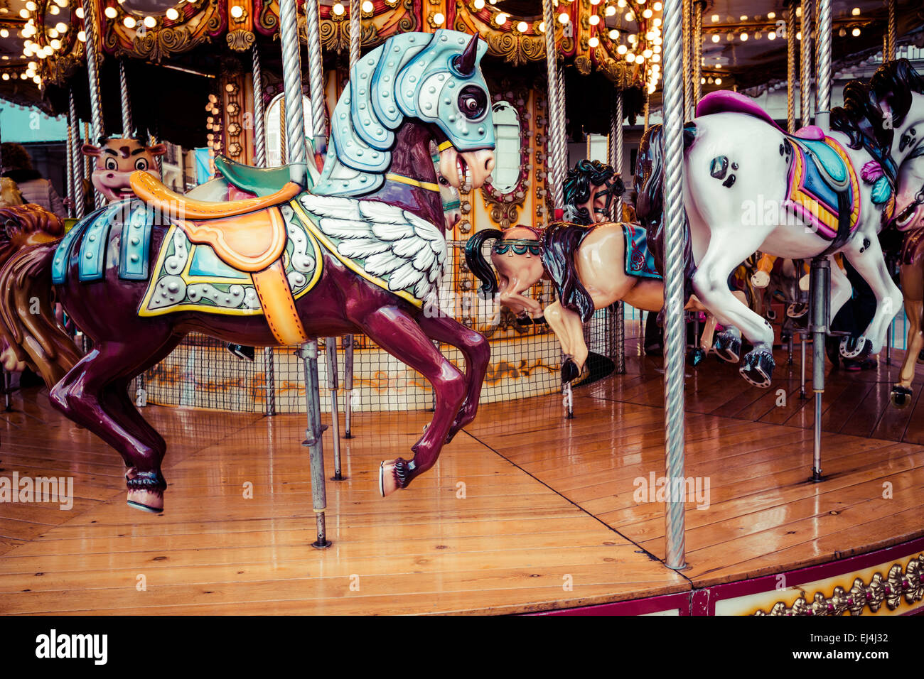 Old French carousel in a holiday park. Three horses and airplane on a ...