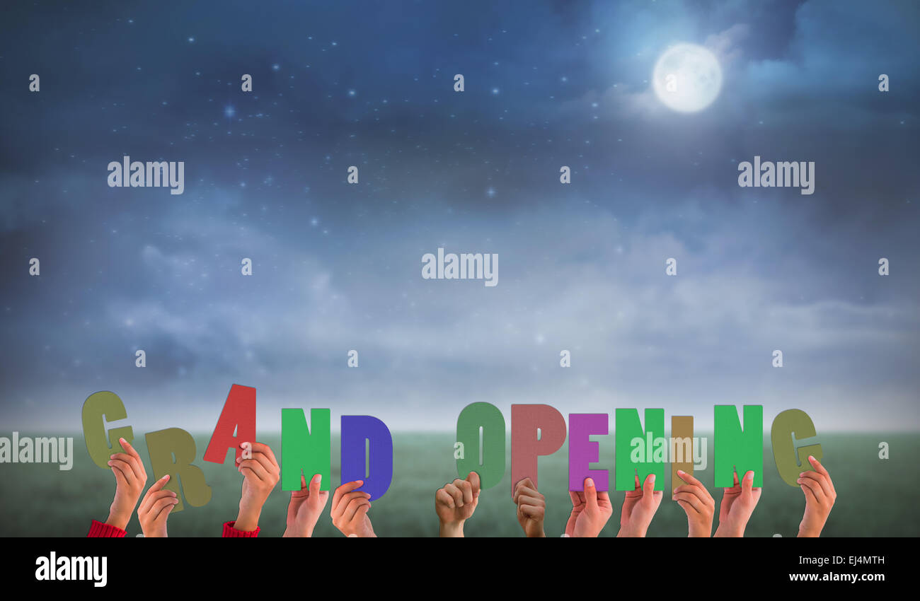 Composite image of hands holding up grand opening Stock Photo - Alamy
