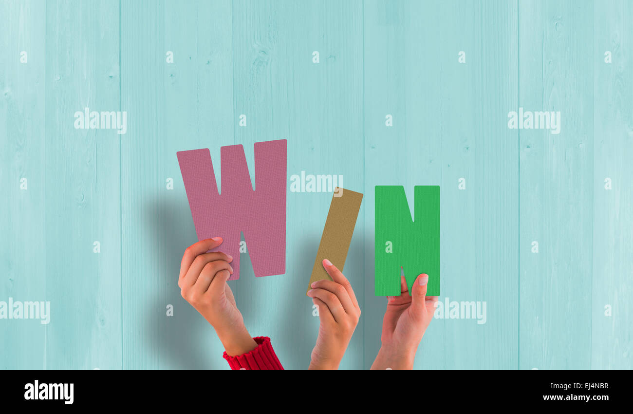 Composite image of hands holding up win Stock Photo - Alamy
