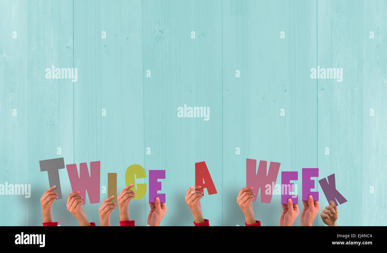Composite image of hands holding up twice a week Stock Photo - Alamy