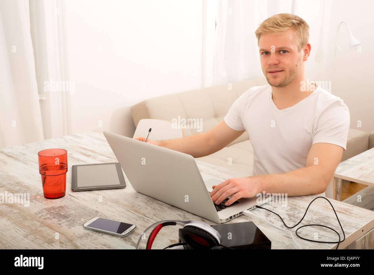 A young caucasian man working in his home office Stock Photo - Alamy
