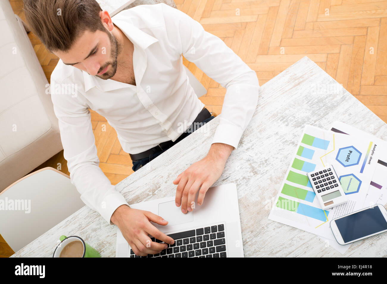 A young man checking his business statistics at home Stock Photo - Alamy