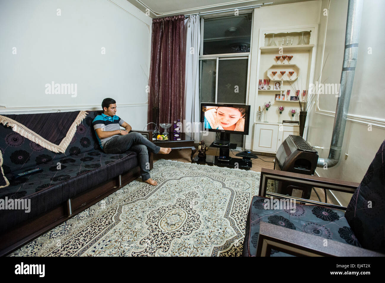 Iranian student Amir watching satellite Turkish TV channel, European or ...