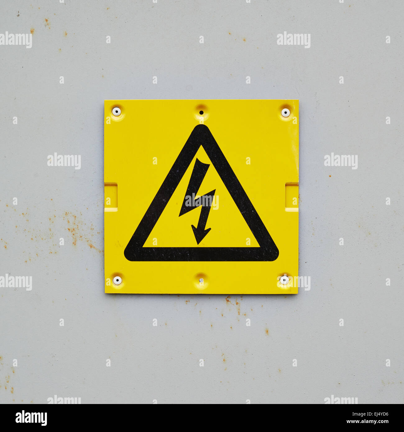 Yellow warning sign on a gray wall Stock Photo - Alamy