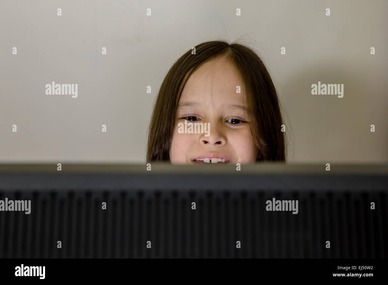 Young girl looking at computer screen smiling Stock Photo - Alamy