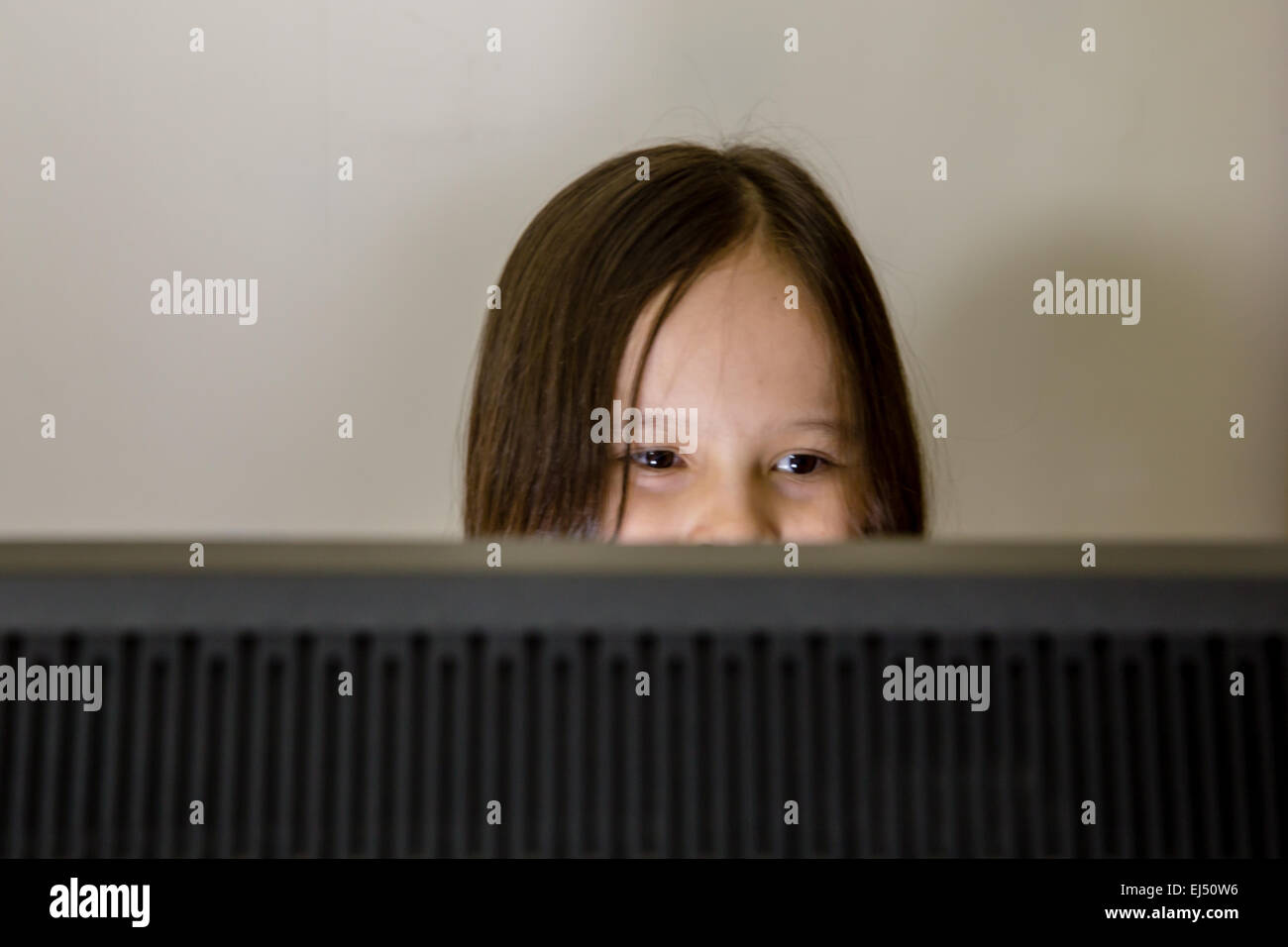 Young girl looking at computer screen, laughing Stock Photo - Alamy