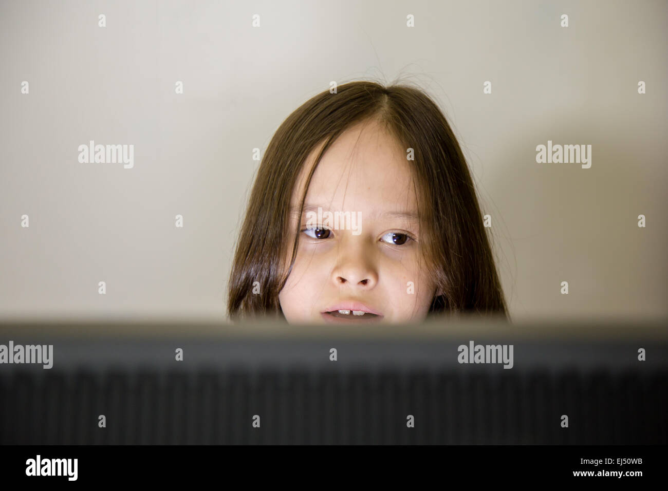 Young girl looking at computer screen Stock Photo - Alamy