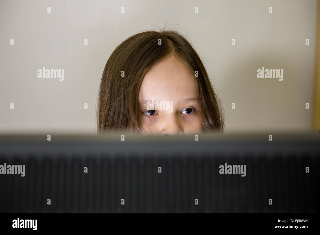 Young girl looking at computer screen Stock Photo - Alamy