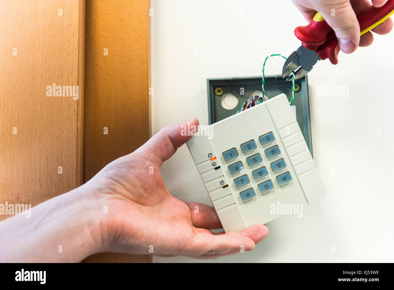 man crosses the wires in the numeric panel. closeup to device Stock ...