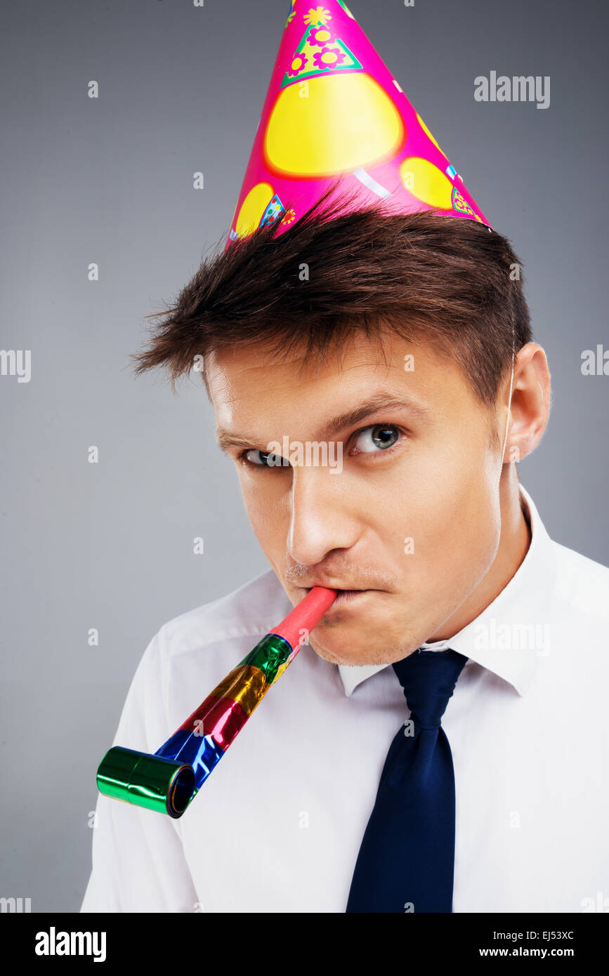 Office manager with party hat and blower Stock Photo - Alamy