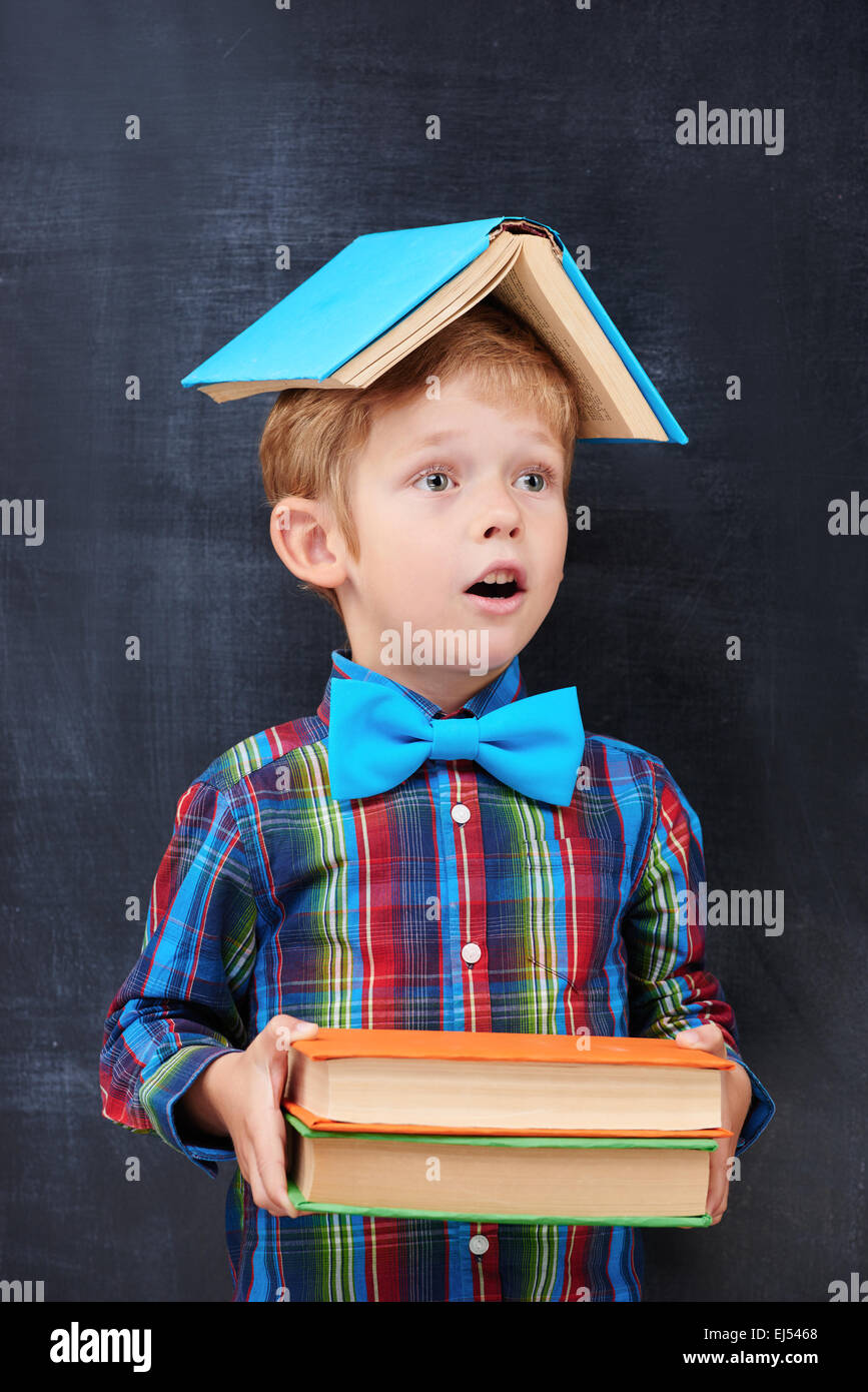 Mixed-up ginger school-boy overloaded with books Stock Photo - Alamy