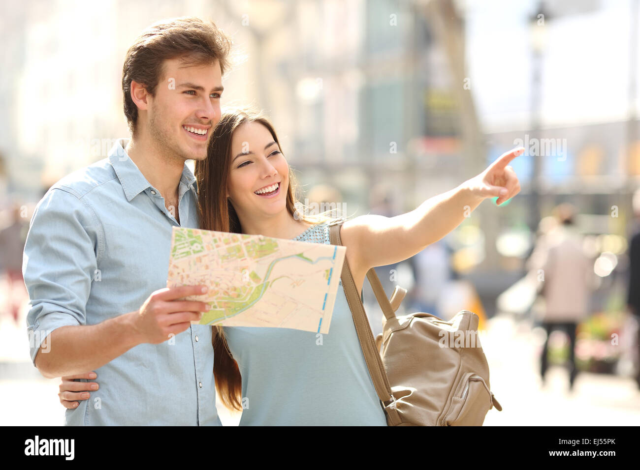Couple of tourists consulting a city guide searching locations in the ...