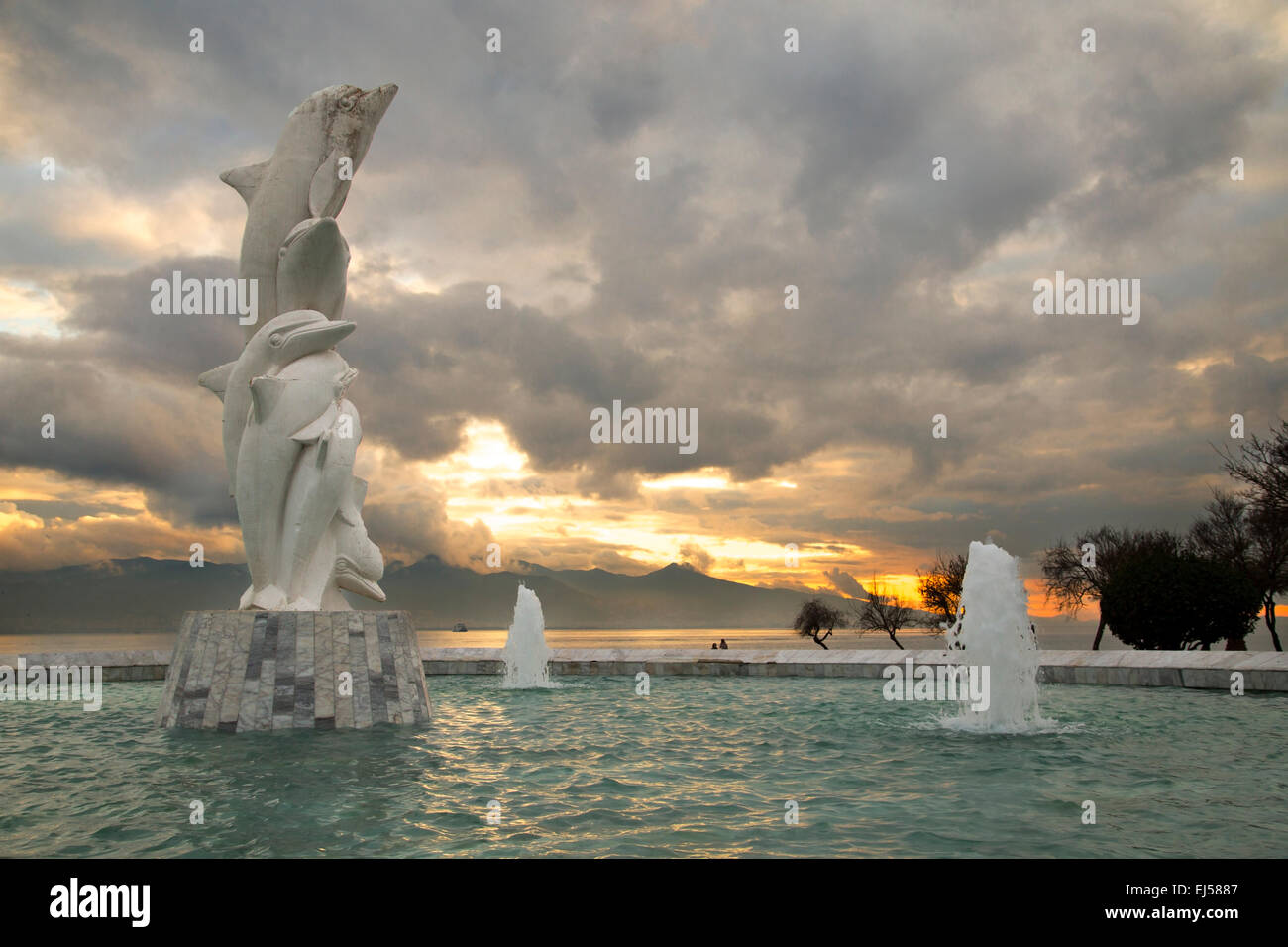 Famous Dolphin statue in a pond with a cloudy sky background during ...