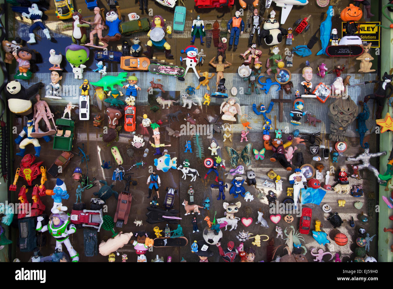 Plastic chotskies toys of super heroes, cars displayed in window ...