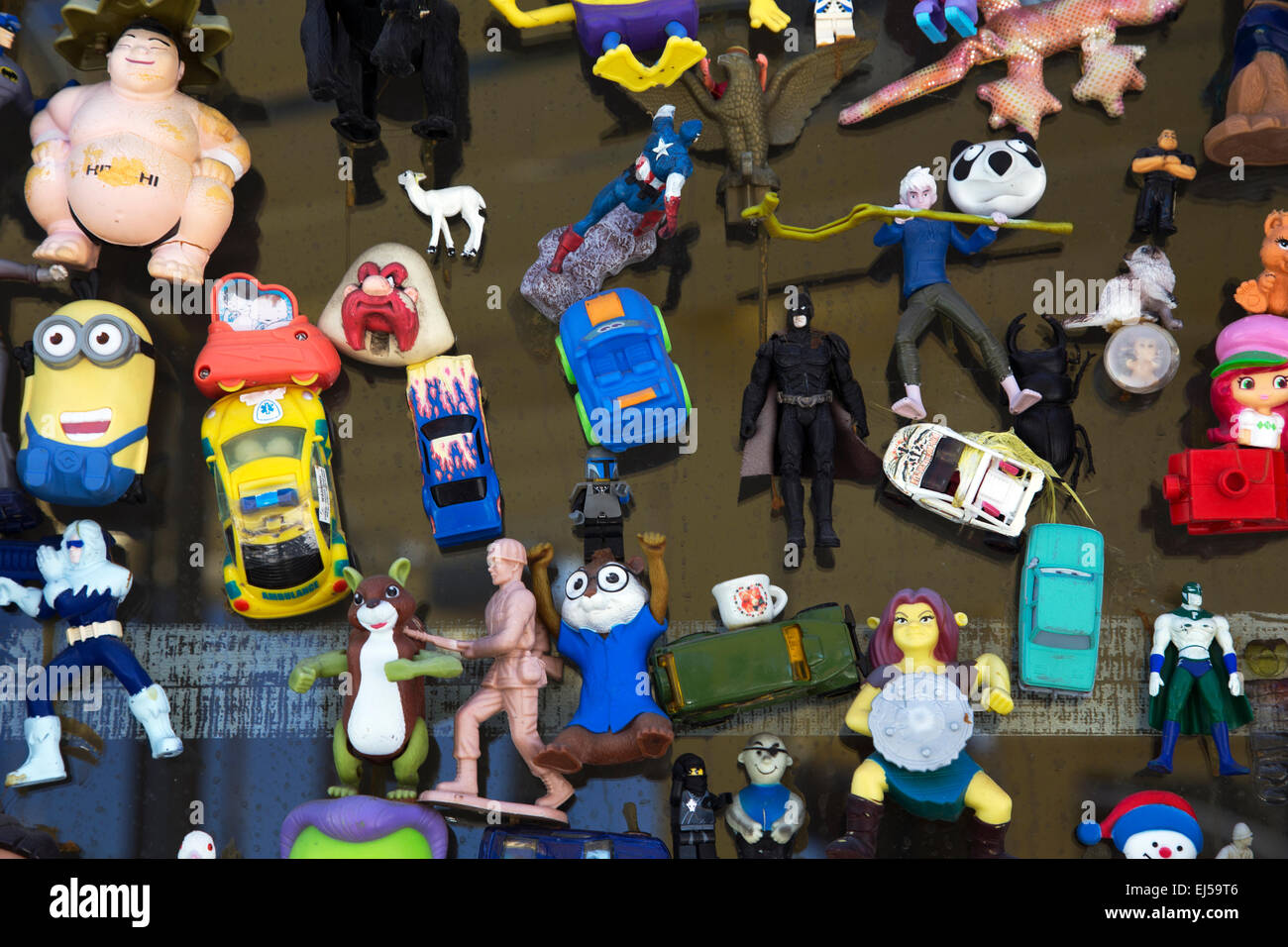 Plastic chotskies toys of super heroes, cars displayed in window ...