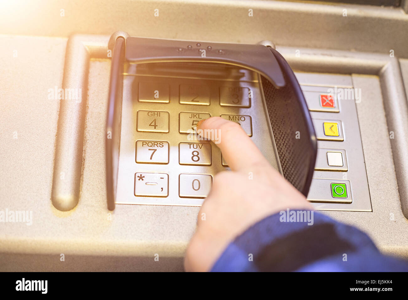 Close-up of hand entering PIN, pass code on ATM, bank machine keypad ...