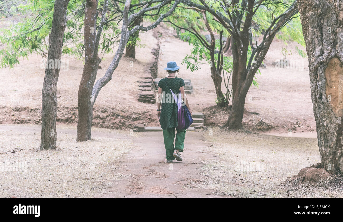 Rear view of lady in traditional local attire walking alone in the ...