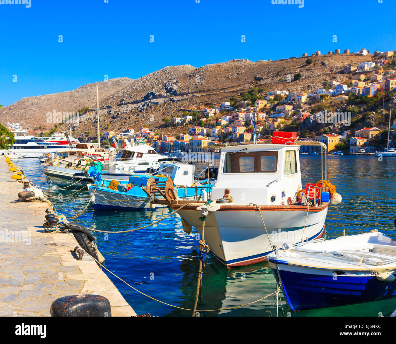 Traditional Greek fishing boats in harbour at Symi Town in the ...