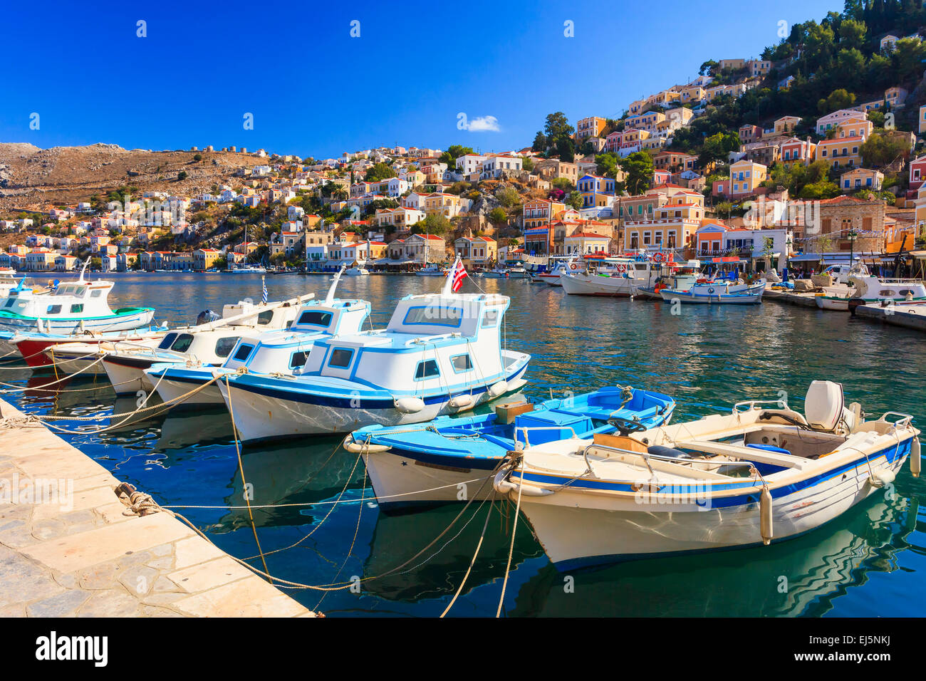 Traditional Greek fishing boats in harbour at Symi Town in the ...