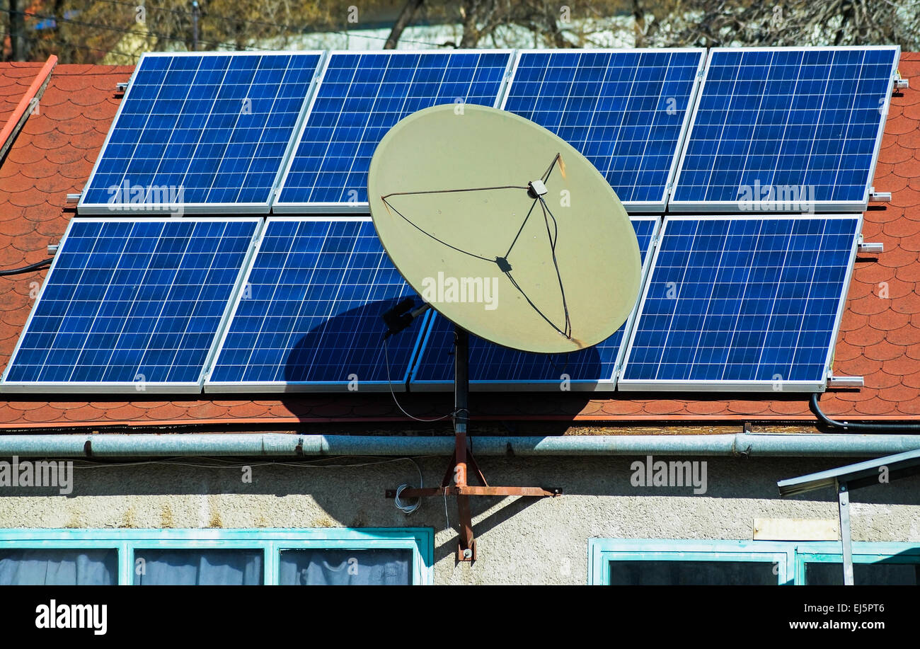 Solar panels and a satellite dish on the roof of a building Stock Photo ...