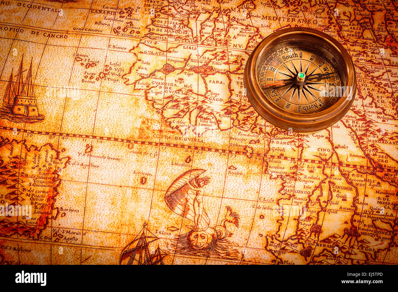 Vintage still life. Vintage compass lies on an ancient world map in ...