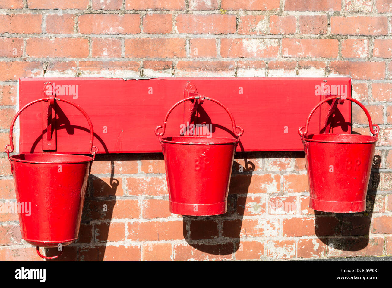Three old fire buckets hanging on a wall Stock Photo - Alamy