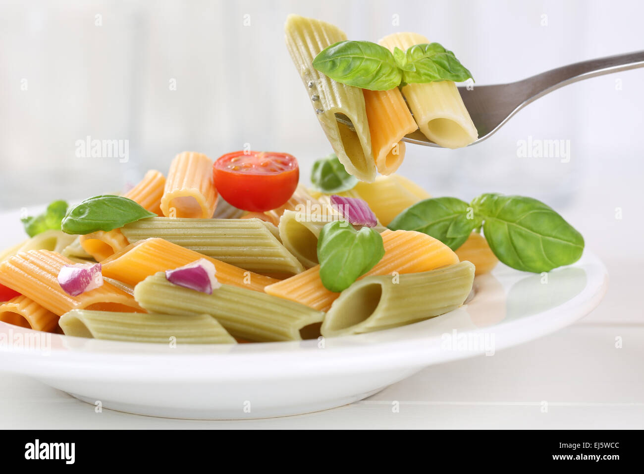 Eating colorful Penne Rigate noodles pasta meal with fork Stock Photo ...