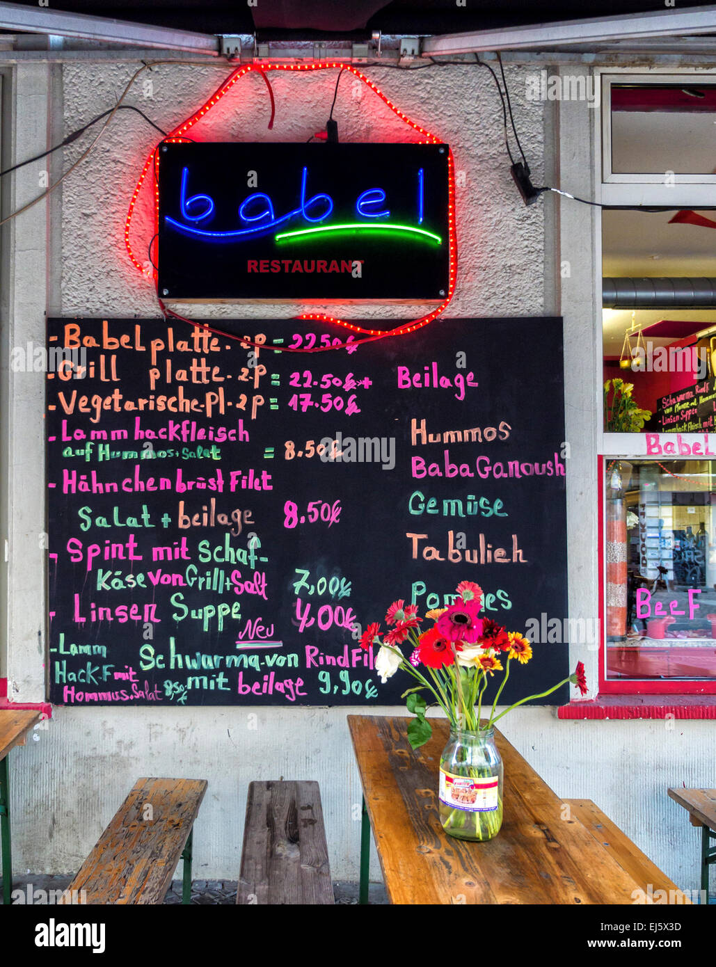 Babel restaurant exterior view, menu board, tables, benches and flowers ...