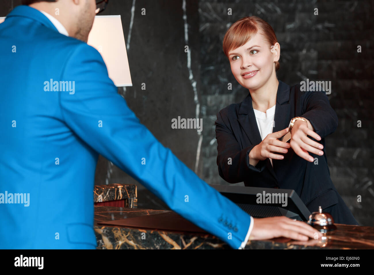 Guest communicating with a receptionist Stock Photo - Alamy