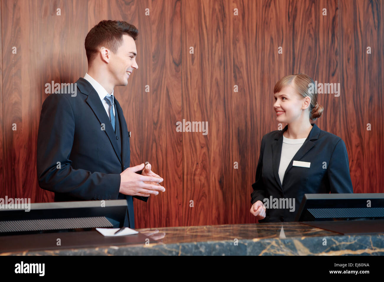 Hotel receptionists behind the counter Stock Photo - Alamy