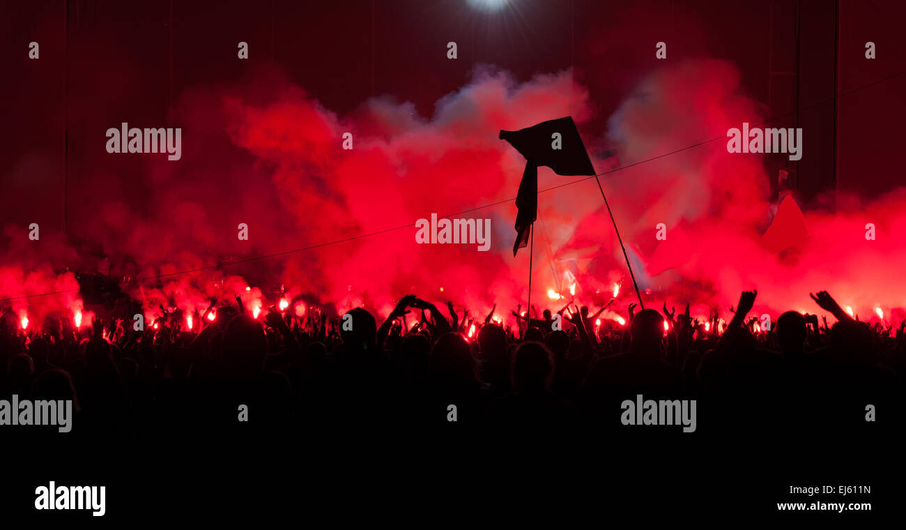 Fans burn red flares at rock concert Stock Photo - Alamy