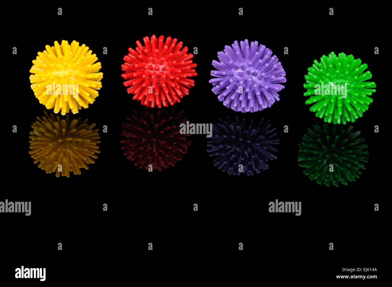 Four colored plastic balls on black background Stock Photo - Alamy