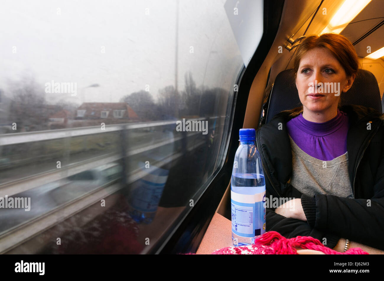 A woman looks out the window of a train looking sad Stock Photo - Alamy